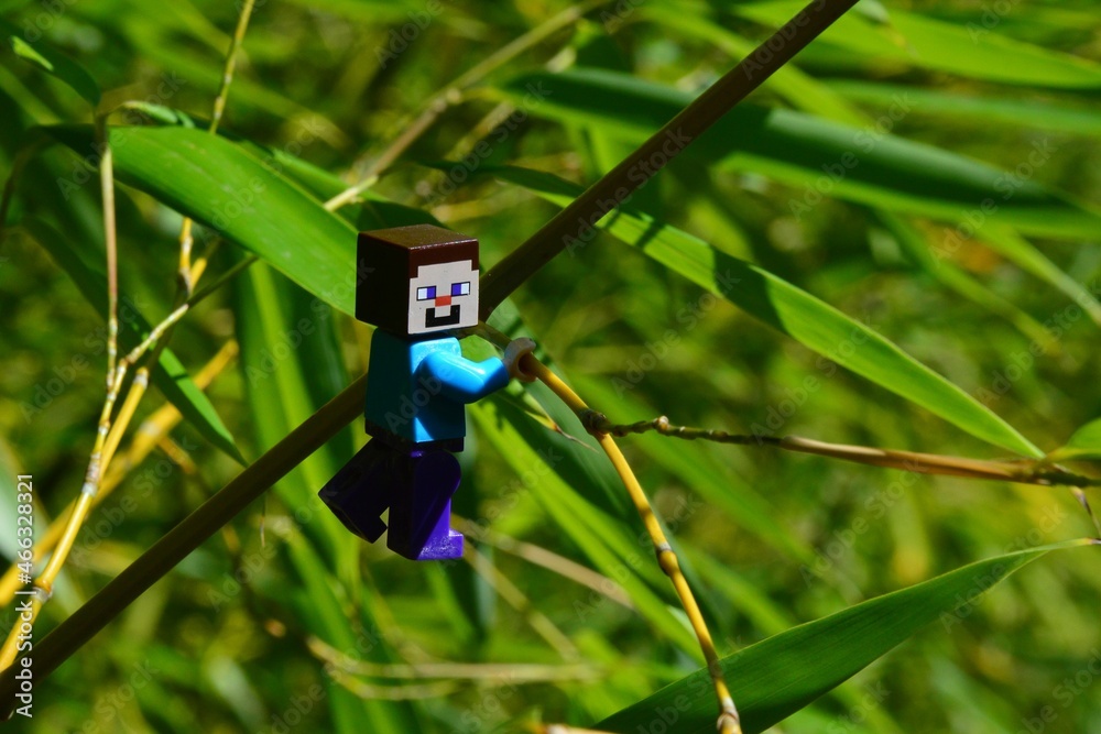 LEGO Minecraft figure of Steve climbing on stalk of bamboo plant ...