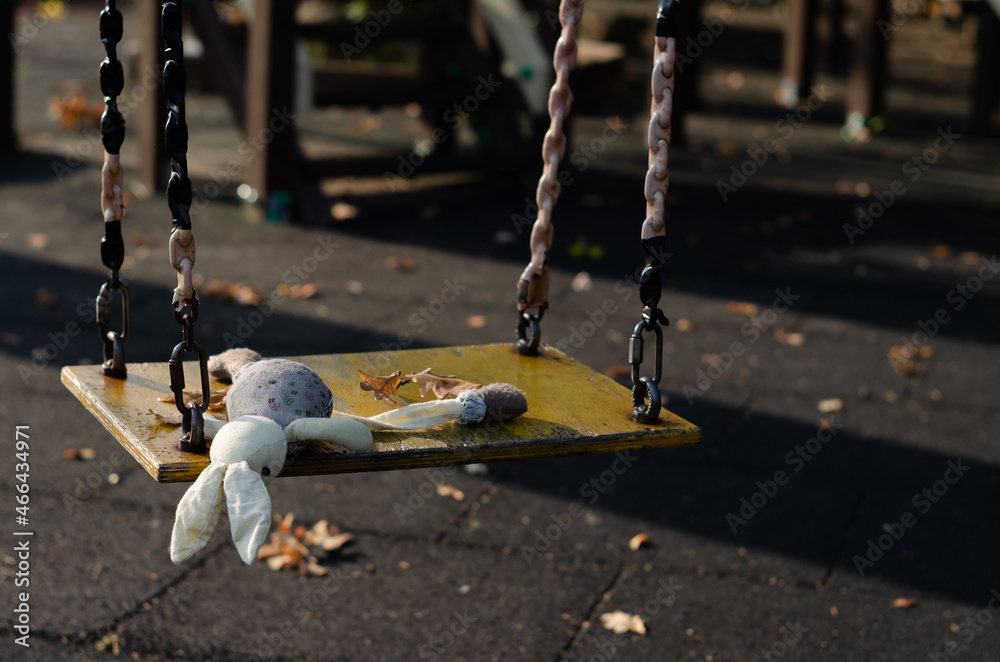 A lost toy on a children's swing in the fall. A toy was lost on the ...