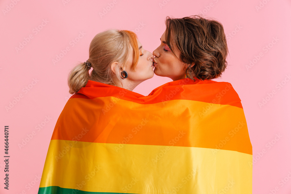Excited Lesbian Couple Kissing While Posing With Rainbow Flag Stock