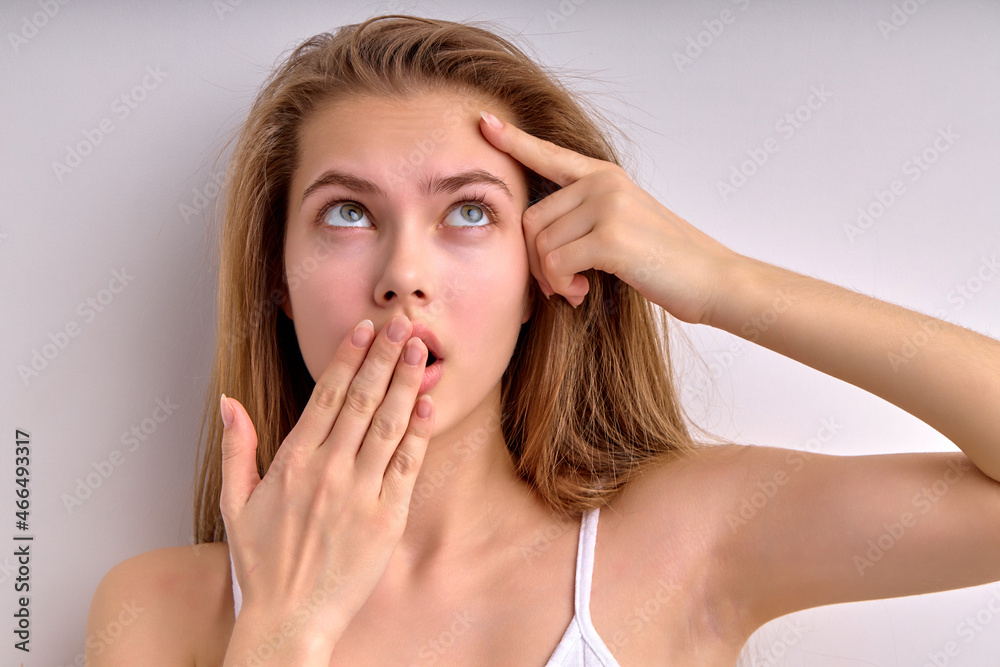 Surprised young female feeling stressed upset about facial skin problem ...