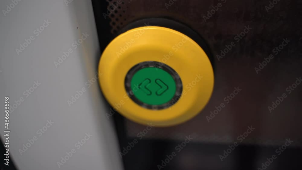 Illuminating push button on metro train doors, yellow and green button ...