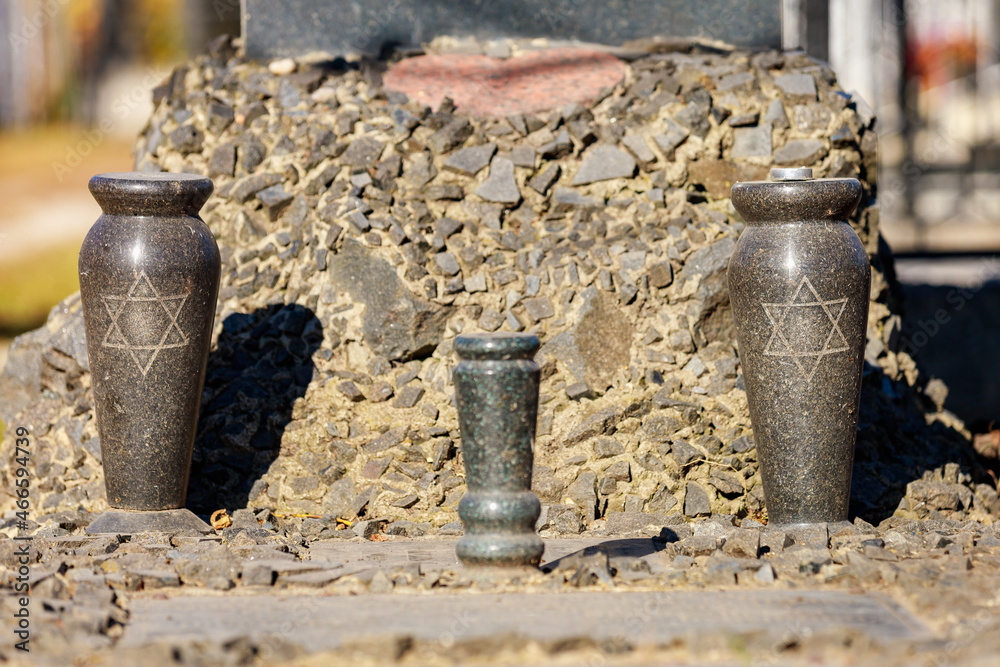 A gravestone with traditional Jewish symbols in the Jewish cemetery ...