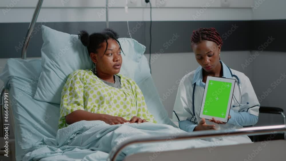 Doctor and patient using digital device with green screen in hospital ...