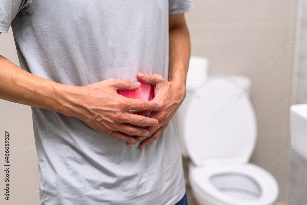 A man standing has diarrhea and severely toxic food. Man touch belly in ...