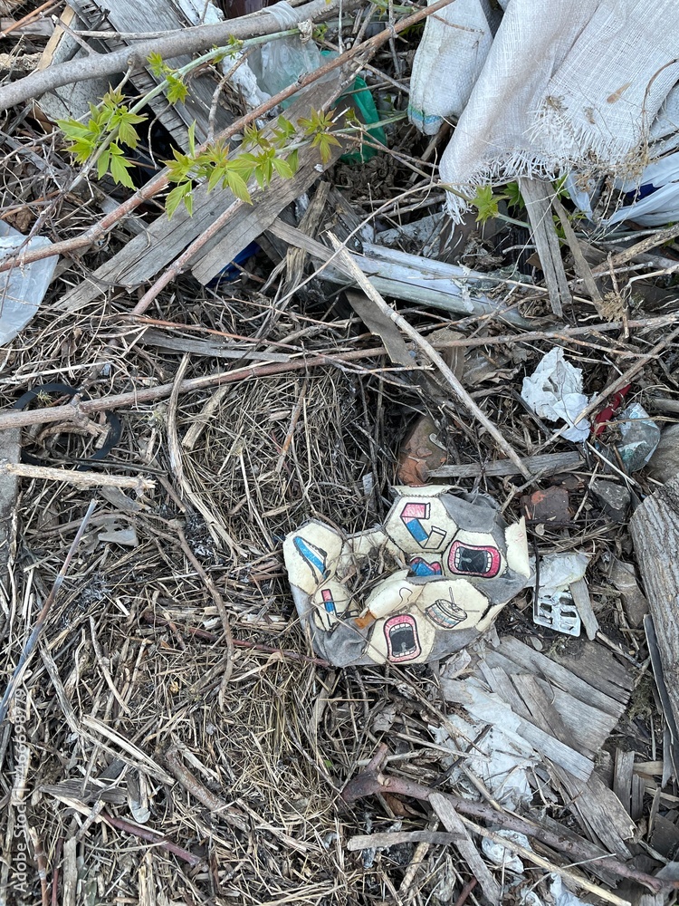 Pile of garbage and a broken ball with shouting mouth print on it ...