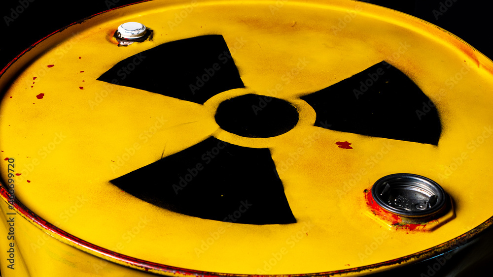 Yellow metal barrel with radioactive decay symbol on top. Container ...