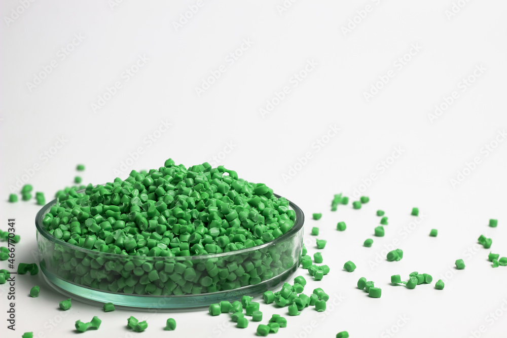 Green granules of polypropylene or polyamide on a white background ...