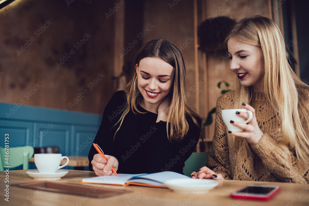 Happy female friends taking notes in planner Stock Photo | Adobe Stock