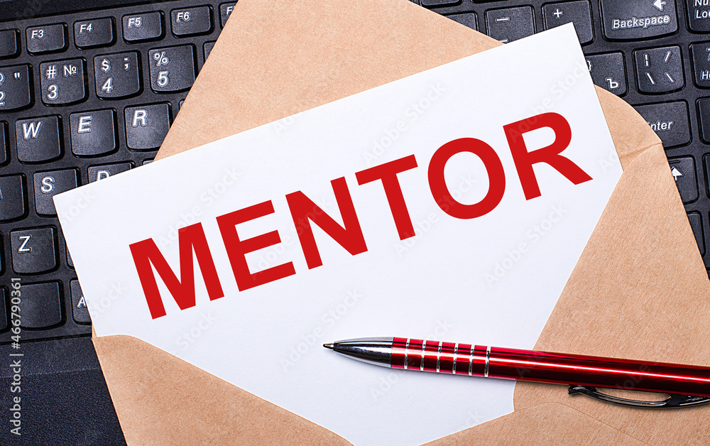White card with the text MENTOR in a craft envelope on a work desk with ...