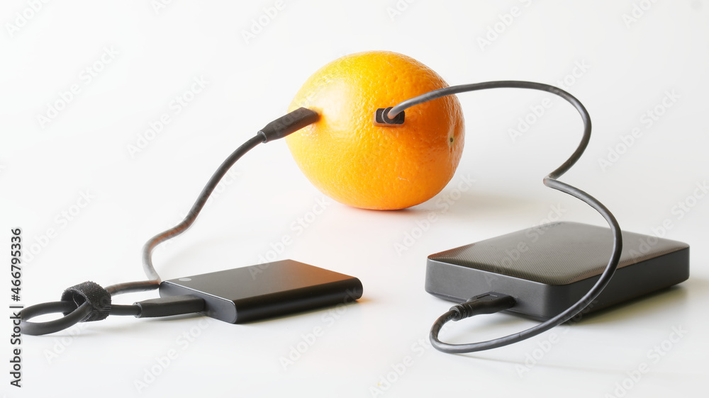 External HDD and external SSD are connected to fresh orange. Concept of ...