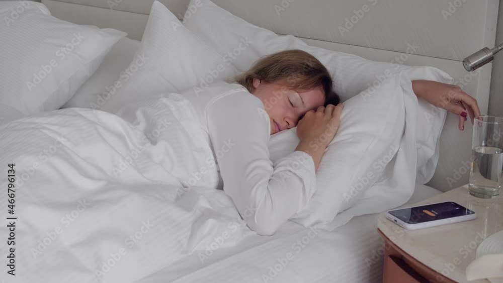 The girl is sleeping in the bedroom and she was woken up by a timer on ...