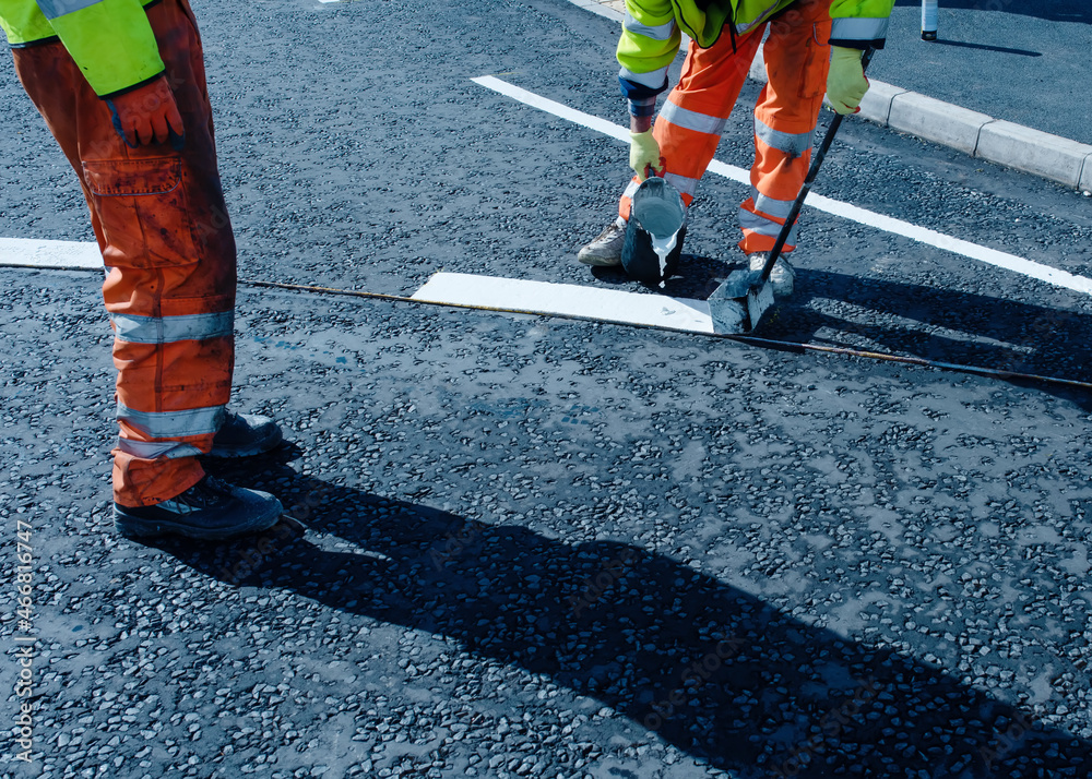Roadworker applying thermoplastic road marking on the freshly laid ...