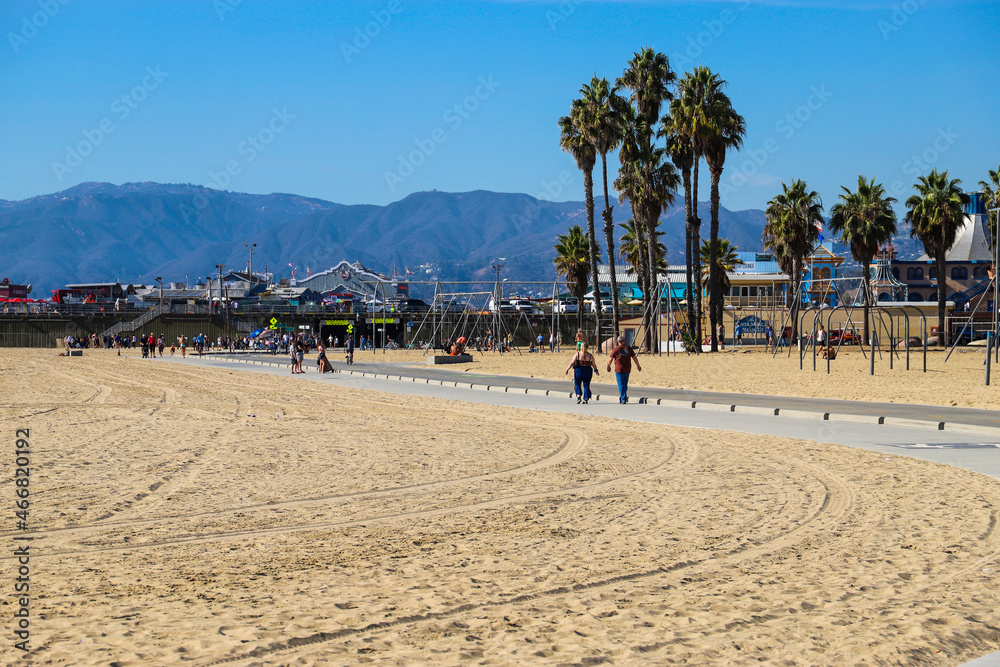 a shot of a long smooth winding bike path at the beach with people ...