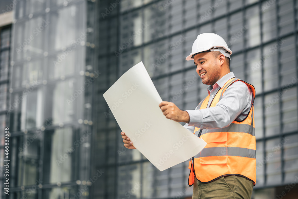 Asian engineer handsome man or architect open the paperwork blueprint ...
