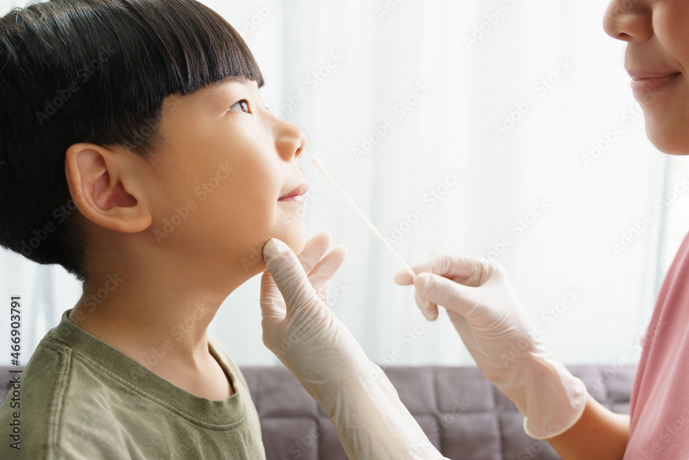 Covid 19 testing before back to school concept. An asian mom gently do ...