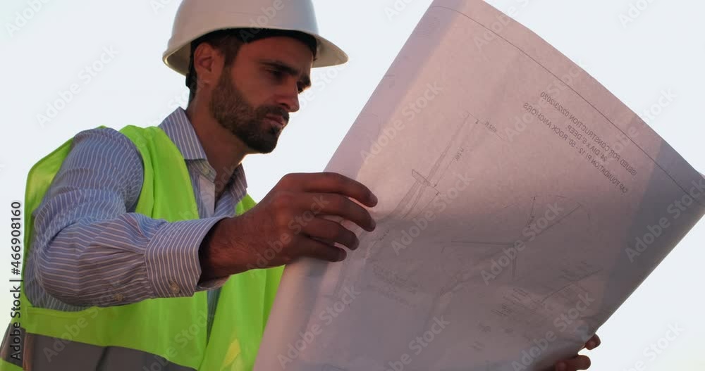 Engineer with brunet hair and stubble wearing helmet and reflective ...