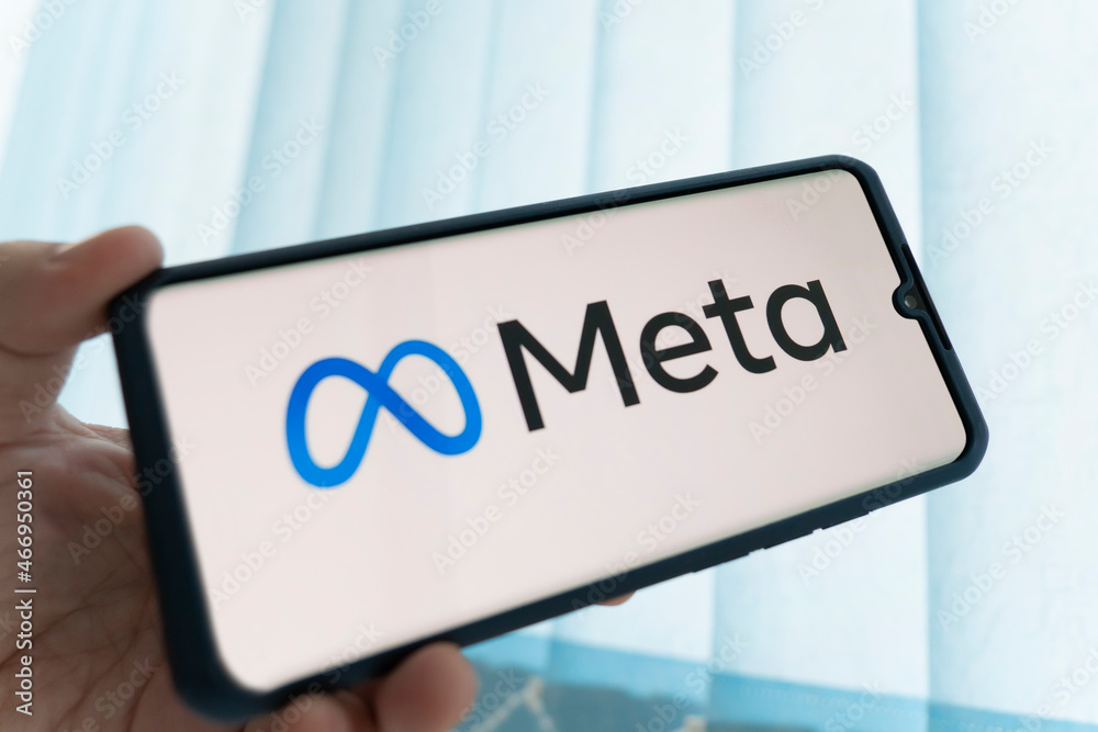 Meta logo is shown on a smartphone screen. Meta is the new corporate ...