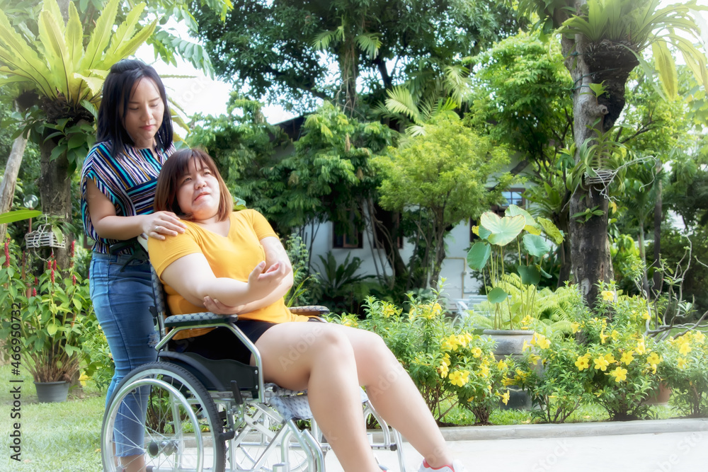 Healthy female friend takes care of her friend who is paralyzed, weak ...