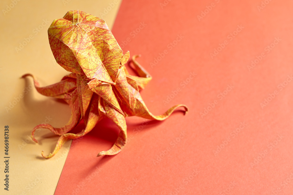 Origami octopus model on a yellow and orange background. Origami figure ...