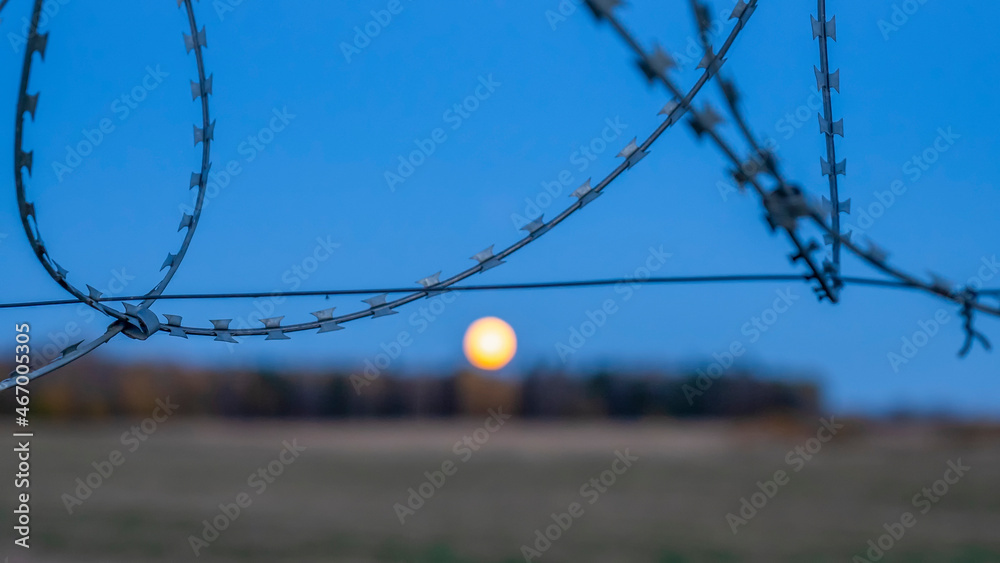 Barbed wire over abstract full moon sky background. Border with barbed ...