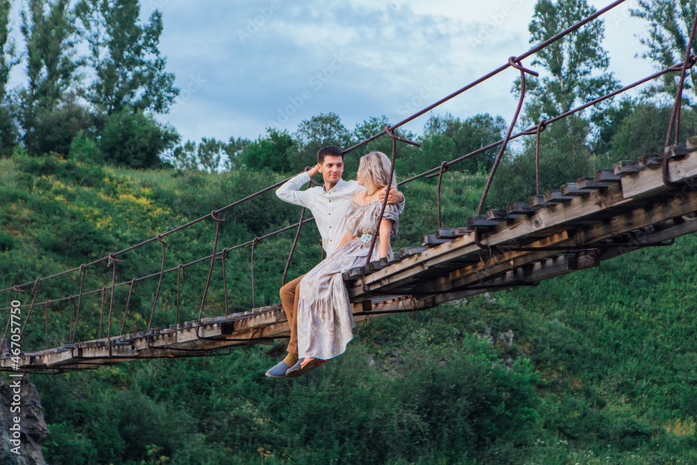 Beautiful young romantic couple sitting and hugging on the suspension ...