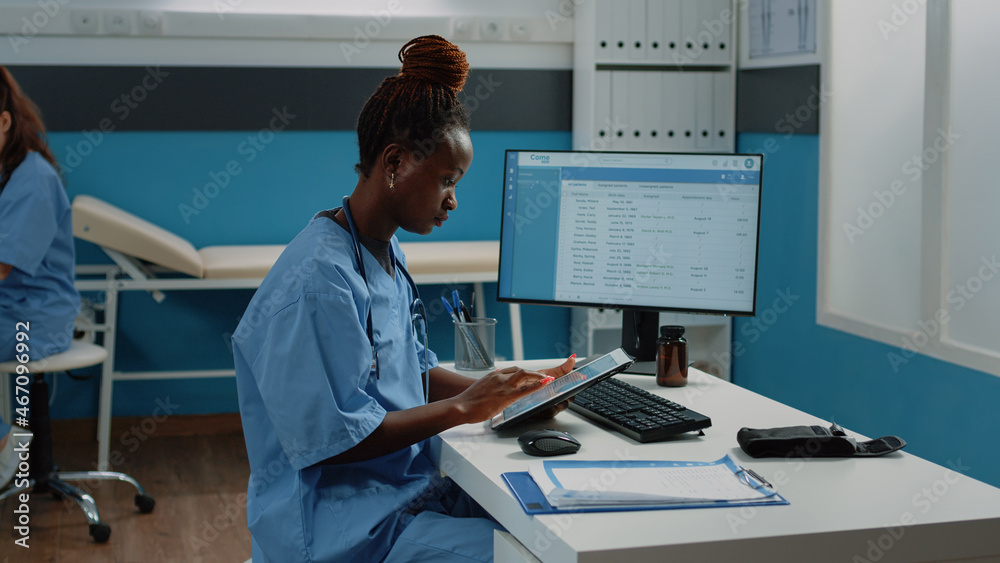 African american nurse using digital tablet for treatment. Black ...
