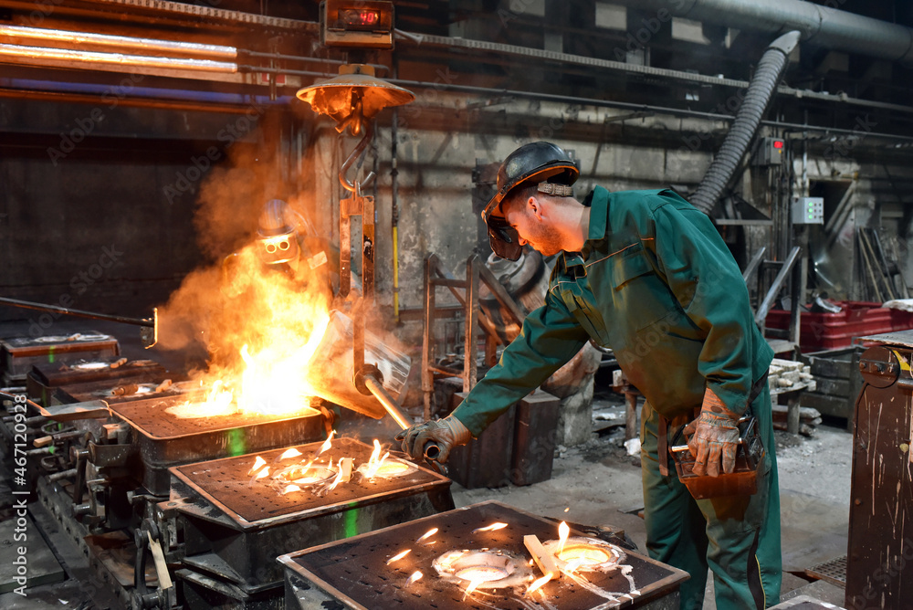 workers in a foundry casting a metal workpiece - safety at work and ...