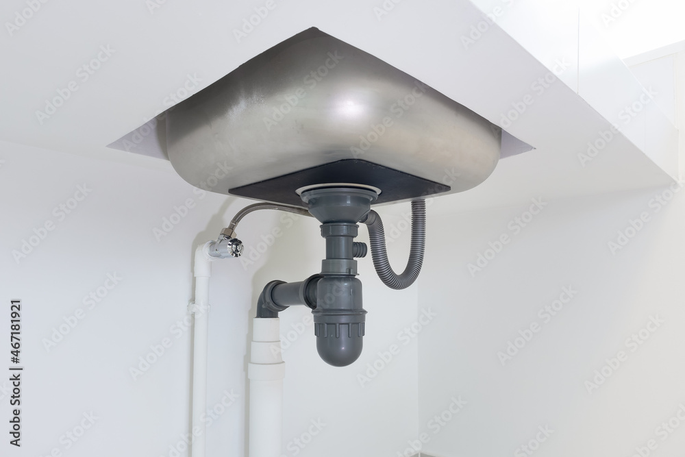 Drain pipe or sewer under kitchen sink. Pvc plastic pipe and flexible ...