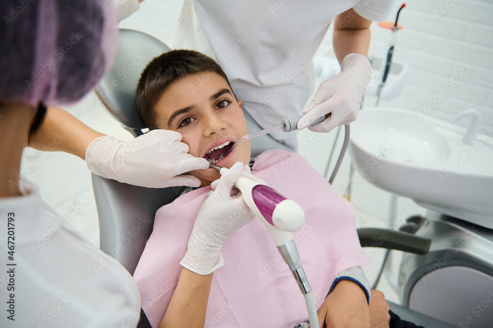 Brave school boy in the dentist's chair during a dental check-up ...