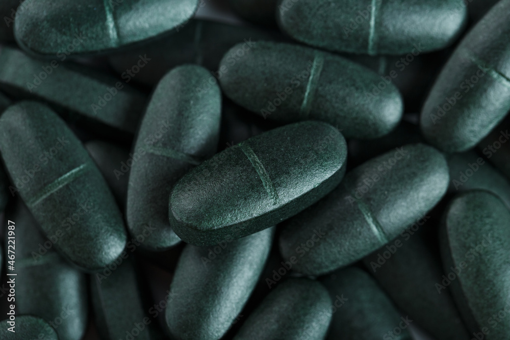 Green tablets of vitamins from spirulina as a textural background in ...