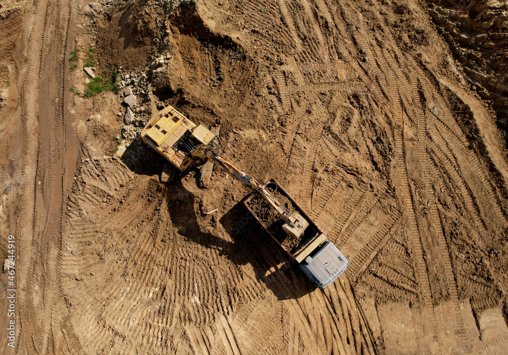 Excavator load the sand into dump truck. Aerial view of an backhoe on ...
