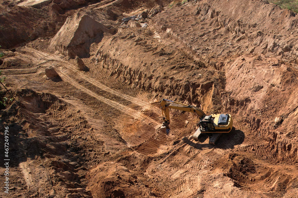 Foto de Excavator dig ground at a construction site. Trench for laying ...