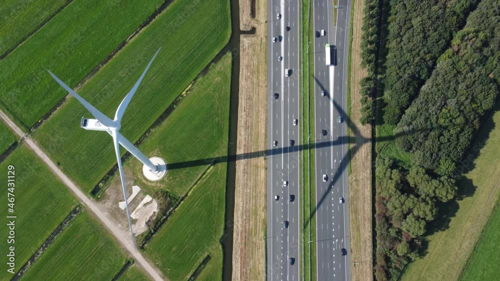 Aerial top down view of wind turbine and highway with traffic moving ...
