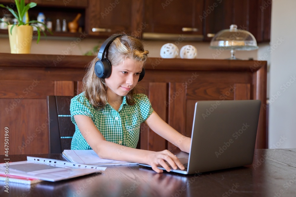 Pre-teen girl with laptop and headphones studies at home. Stock Photo ...