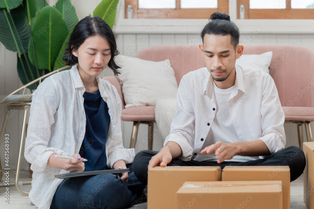 Young couple packing cardboard boxes at new home.Moving house.Real ...