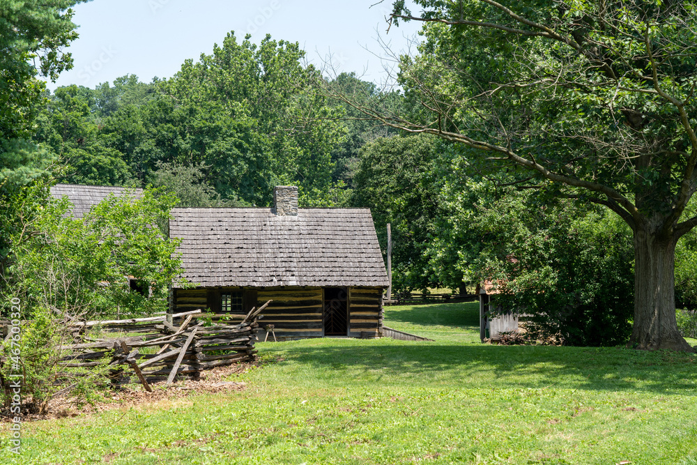 Foto de Old log cabin and a split rail fence under the spreading tree ...