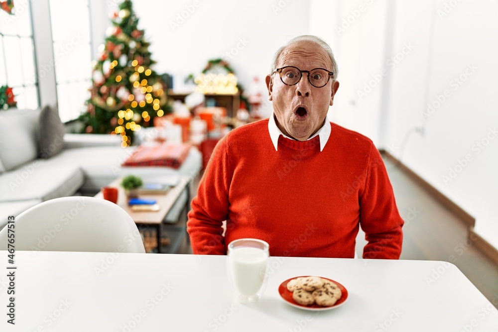 Senior man with grey hair sitting on the table with cookies by ...