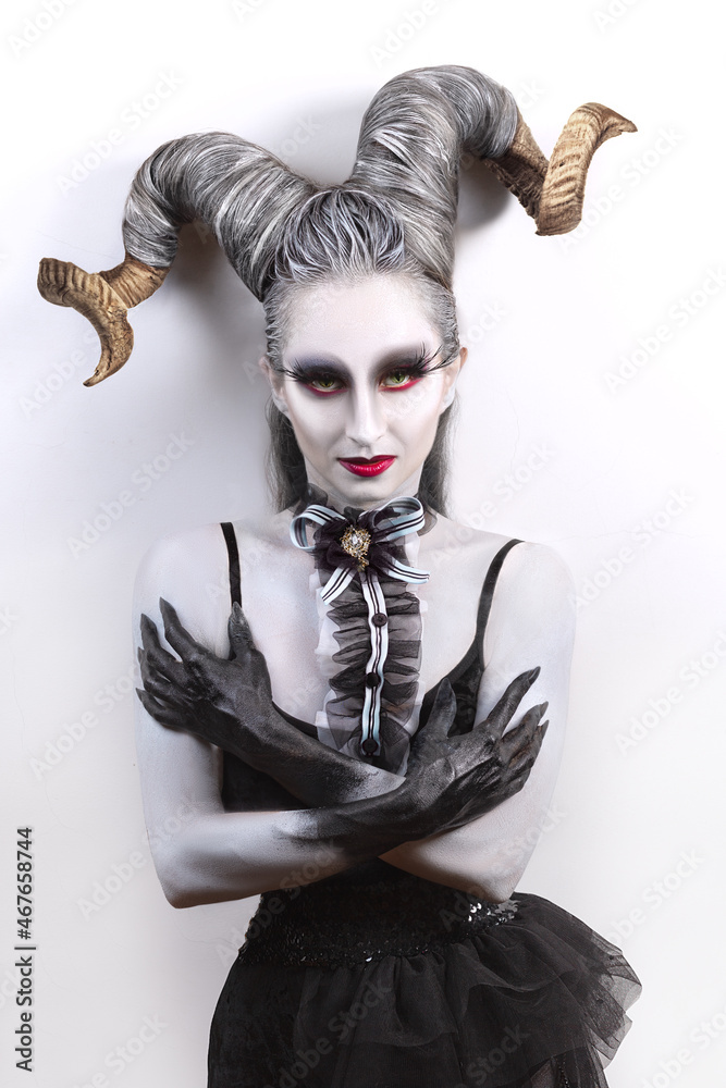 Portrait of beautiful Halloween monster woman with horns against white ...