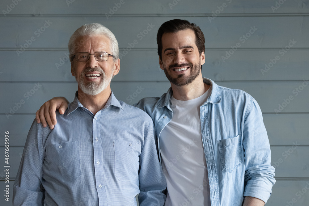 Father and son portrait. Smiling mature dad young adult child hug look ...