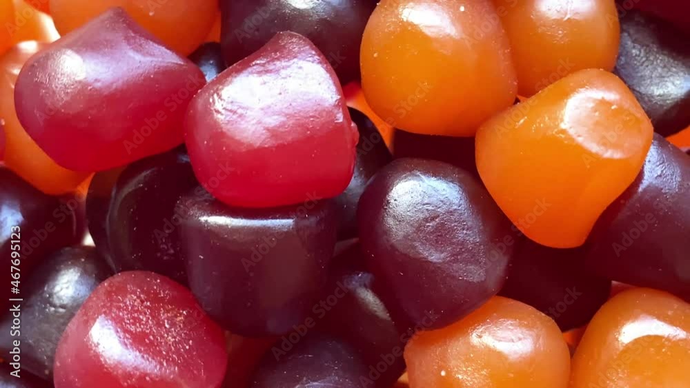 Close-up texture of red, orange and purple multivitamin gummies on ...