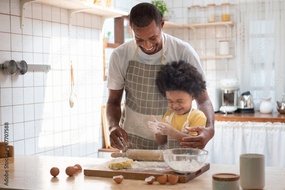 African American boy enjoy cooking with his father in kitchen together ...