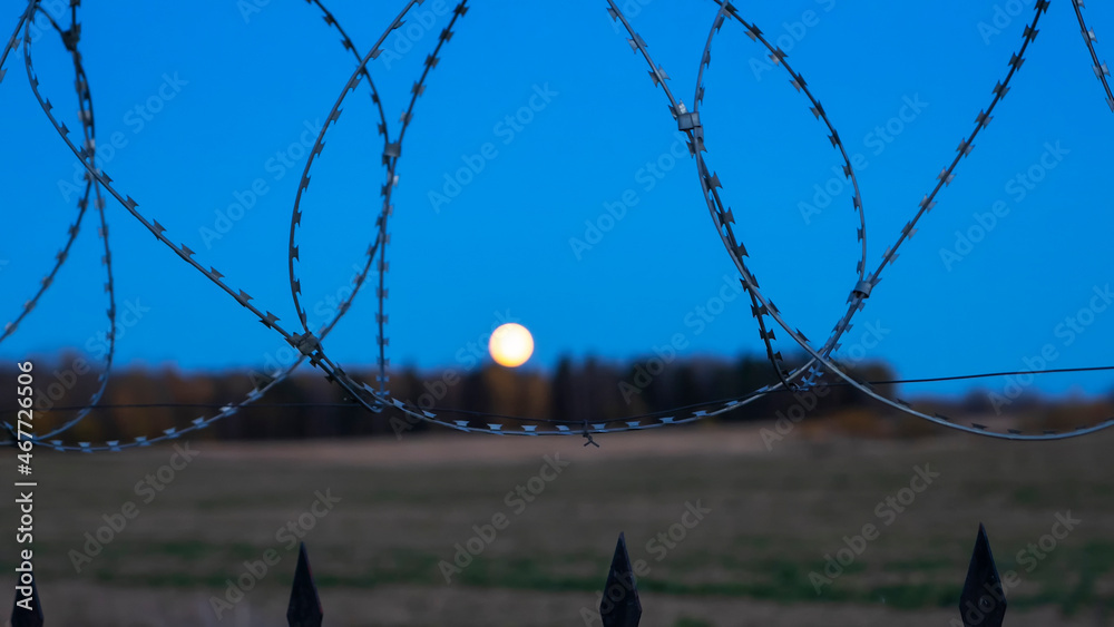 Barbed wire over abstract full moon sky background. Border with barbed ...
