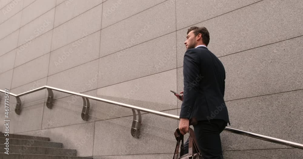 camera moves up. rear view. man walking up the stairs. Business people ...