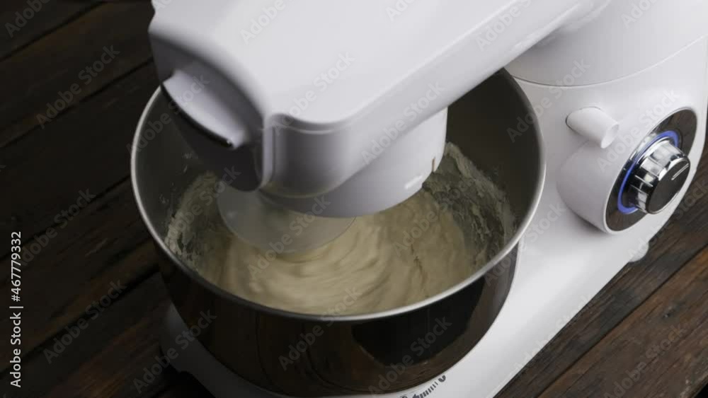 Slow motion. Kneading the dough in the bowl of the planetary mixer ...