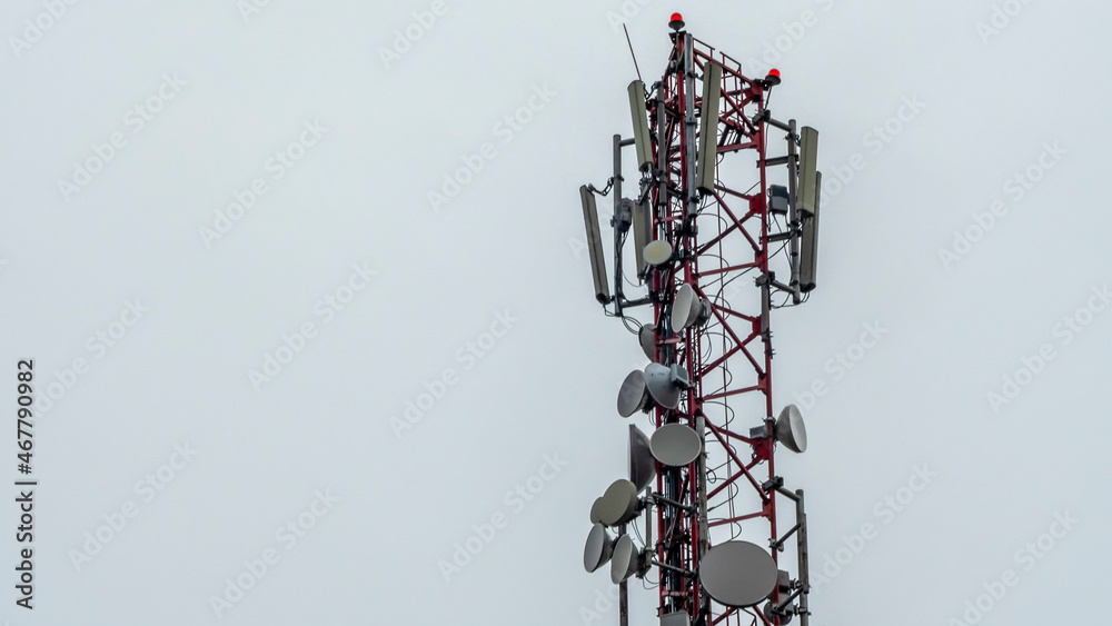 Tower with mobile operator antennas on the dramatic sky background ...