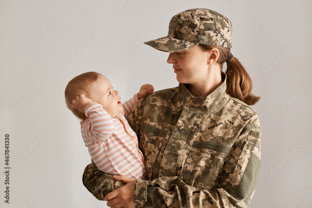 Caucasian female soldier wearing camouflage uniform and cap, standing ...