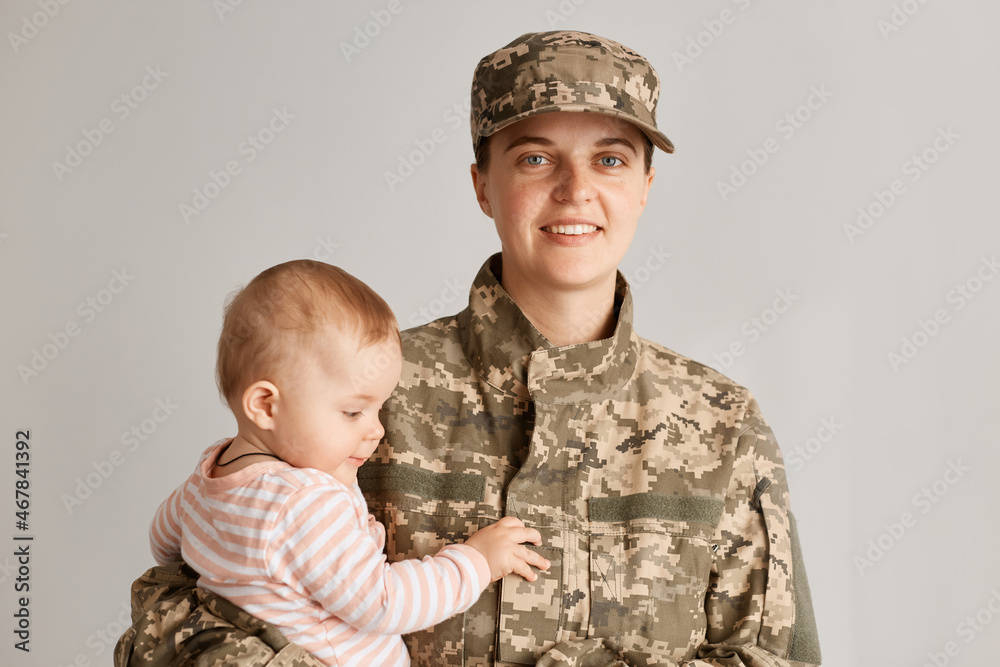 Charming little girl with her military mother, woman soldier holding ...