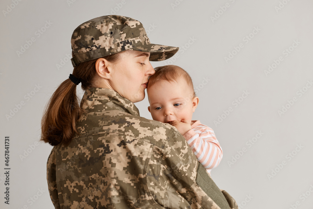 Back side portrait of young adult woman soldier wearing camouflage ...