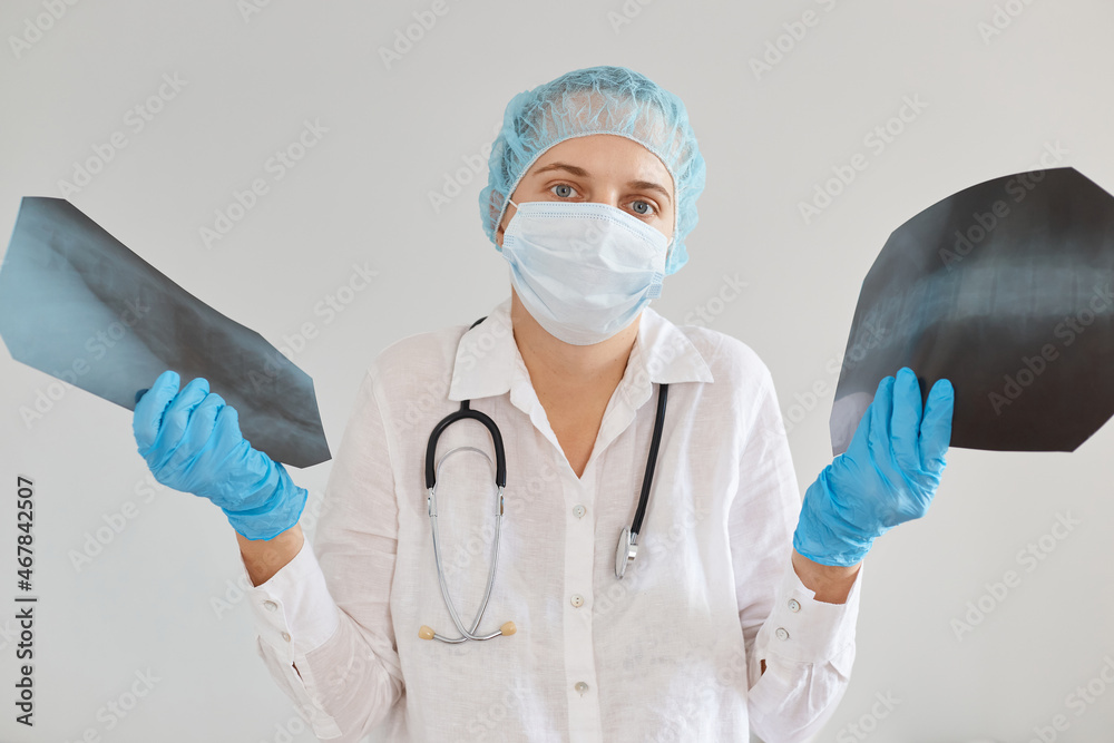Indoor shot of confused female doctor wearing medical uniform, cap and ...