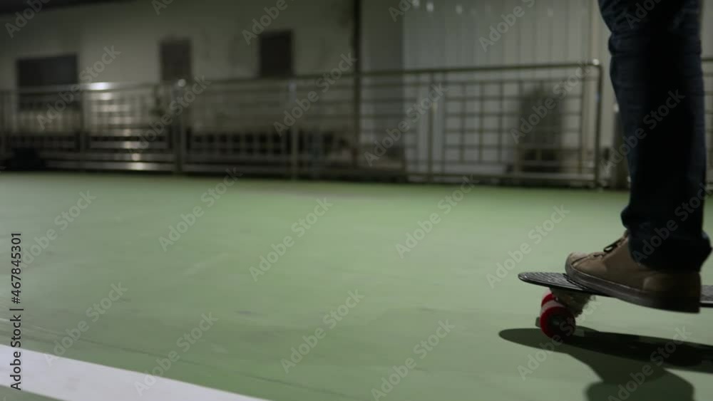 Close up male professional skateboarder standing on a penny board ...